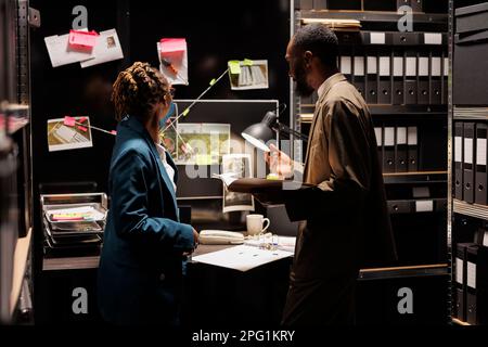 Police agents examine evidence board in investigation office, analyzing ...