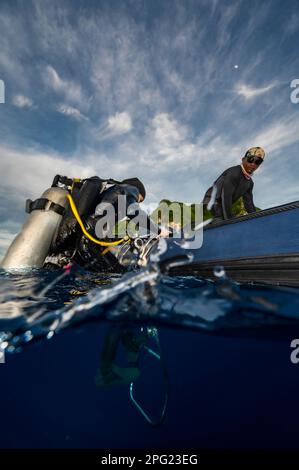 Diver climbing into dinghy after a dive in Banda Sea Stock Photo - Alamy