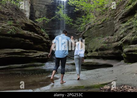 A couple walking towards a waterfall at Matthiessen State Park Stock ...