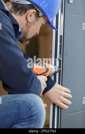 builder with drill inserting door frame to aperture Stock Photo - Alamy