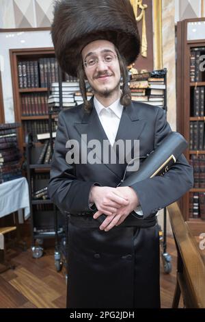 Posed portrait of a hasidic man wearing a shtreimel fur hat in an empty ...