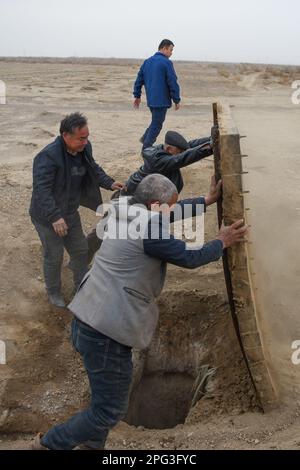 230320 -- URUMQI, March 20, 2023 -- A farmer pours water fetched from ...