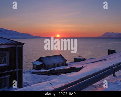 Sunset over the mine. Russian coal mining town Barentsburg at fjord ...