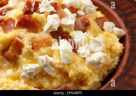 Delicious traditional Ukrainian banosh in wooden bowl on table, closeup ...