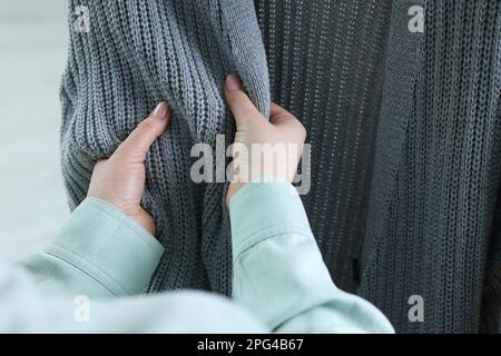 Woman touching clothes made of soft knitted fabric, closeup Stock Photo ...