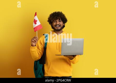 Handsome young man with flag of Canada and passport on green background ...
