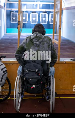 Man in Wheelchair Shooting with a Gun on Shooting Range with Target in ...