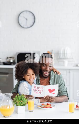 Image of amazed african american girl listening music with earpods ...