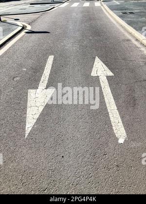 Road with two arrows pointing into opposite directions Stock Photo - Alamy