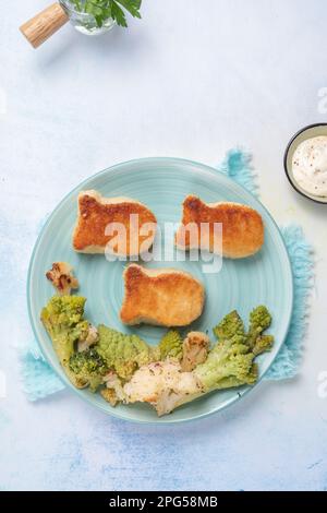 Kids food. Fish shaped nuggets with vegetable Stock Photo - Alamy