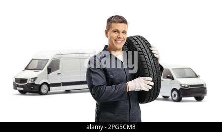 Auto mechanic worker carrying a tire on shoulder and smiling at camera ...