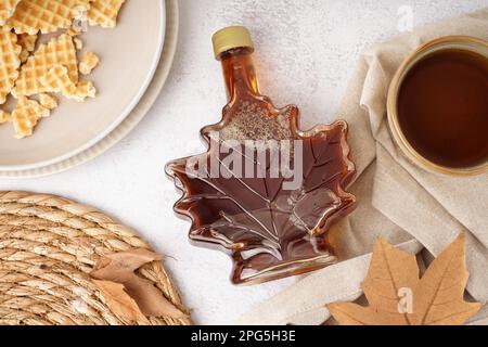Beautiful composition with bottle of maple syrup and waffles on white ...
