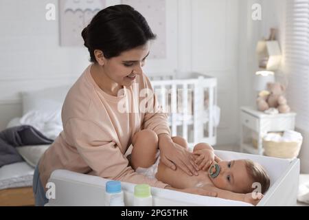 Mother applying dusting powder on her cute baby at home. Banner design ...