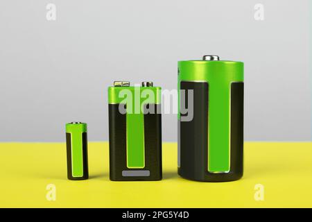 Different types of batteries on color background, space for text Stock ...