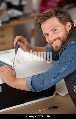 Young male contractor repairing heater Stock Photo - Alamy