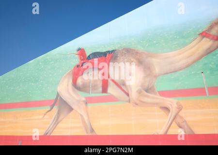 Painted overpass on roadway. It depicts camel racing with robot jockey ...