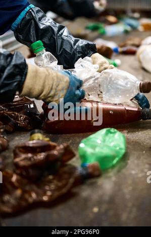 Worker sorts trash on conveyor belt at waste recycling plant Stock Photo - Alamy
