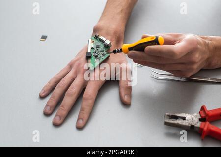 Robot arm concept. Man shows biomechanical prosthetic hand. Guy repairs ...