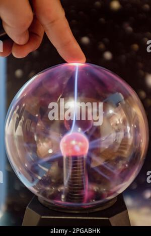 Electricity lighting ray going to a finger hand on a powerful spark ...