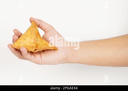 Samosa in hand on white background Stock Photo - Alamy