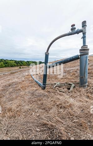 A vertical landfill methane gas wellhead and valve at an active ...
