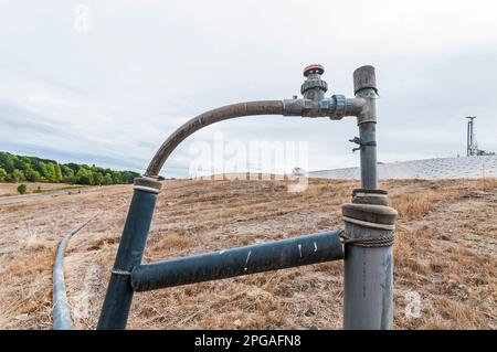 A vertical landfill methane gas wellhead and valve at an active ...