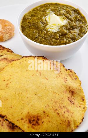Makki roti with saag in plate on white background Stock Photo - Alamy