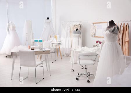 Dressmaking workshop interior with wedding dresses and equipment Stock ...