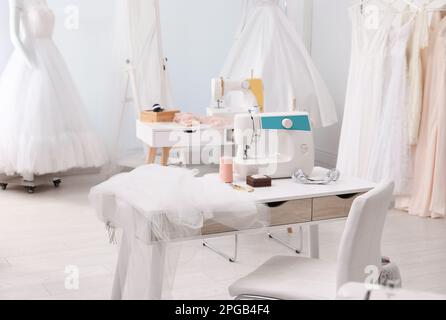 Dressmaking workshop interior with wedding dresses and equipment Stock ...