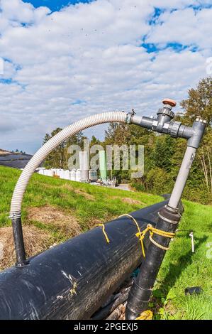 A vertical landfill methane gas wellhead and valve at an active ...