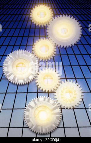 INTERLOCKING COG GEARS WHEELS ON RED GRID Stock Photo - Alamy