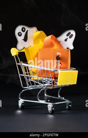 A small cart with bags, gifts and ghosts on the black background ...