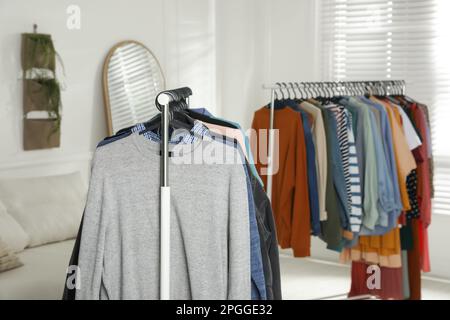 Racks with stylish clothes indoors. Fast fashion Stock Photo - Alamy