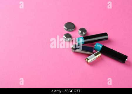Different types of batteries on pink background Stock Photo - Alamy