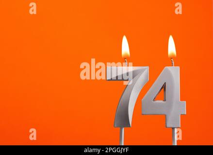 Candle number 74 - Birthday in blues foamy background Stock Photo - Alamy