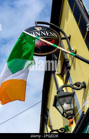 Irish tricolor national flag and Guinness sign outside a bar in County ...