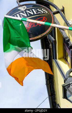 Irish tricolor national flag and Guinness sign outside a bar in County ...