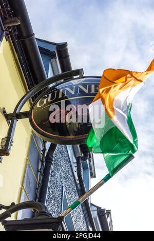 Irish tricolor national flag and Guinness sign outside a bar in County ...