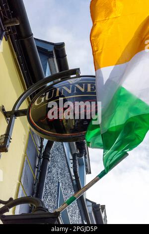 Irish tricolor national flag and Guinness sign outside a bar in County ...