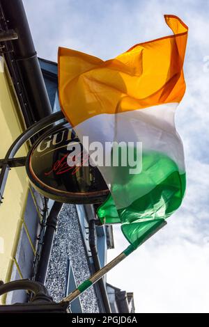 Irish tricolor national flag and Guinness sign outside a bar in County ...