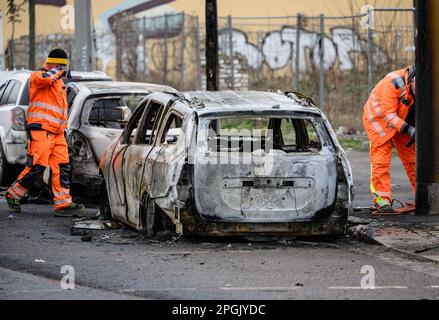 Dresden, Germany. 23rd Mar, 2023. A burnt-out excavator and cars stand ...