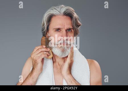 Taking care of face and skin clearness. Stylish modern senior man with ...