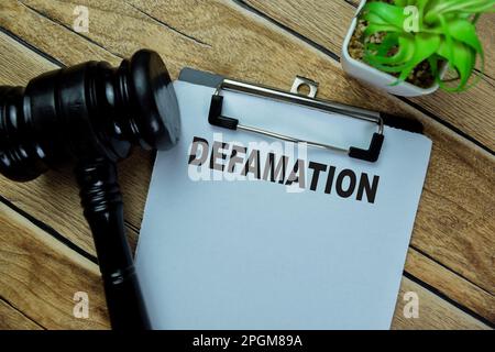 Defamation write on a paperwork isolated on Wooden Table Stock Photo ...