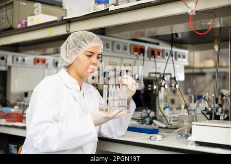 Female pharmacist researcher holding tripod and waiting for color ...