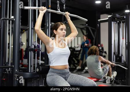 Woman is engaged in a simulator for development of back muscles Stock ...