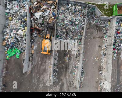 Wheel loader on the landfill site, pushing, scooping and carrying waste ...