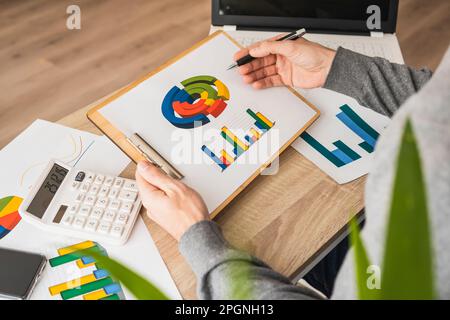 Businessman examining charts and graphs at desk in office Stock Photo ...