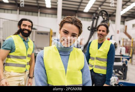 Happy engineers wearing reflective clothing talking with each other in ...