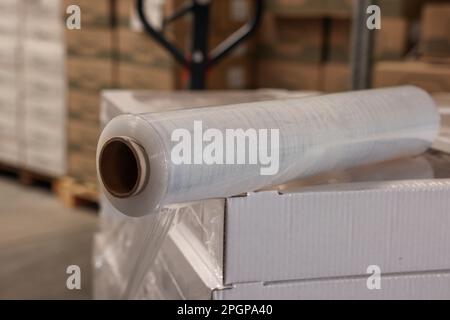 Roll of stretch wrap on box in warehouse Stock Photo - Alamy