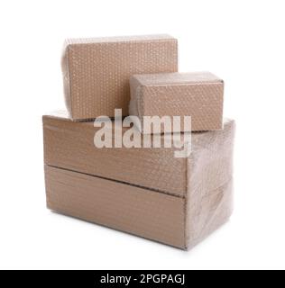 Cardboard boxes packed in bubble wrap on white background Stock Photo ...